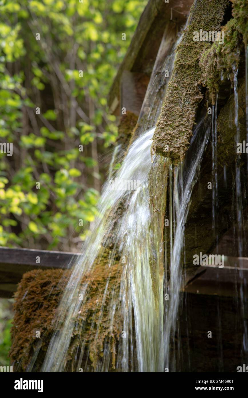A vertical shot of a water inlet to an old mill wheel on the background ...