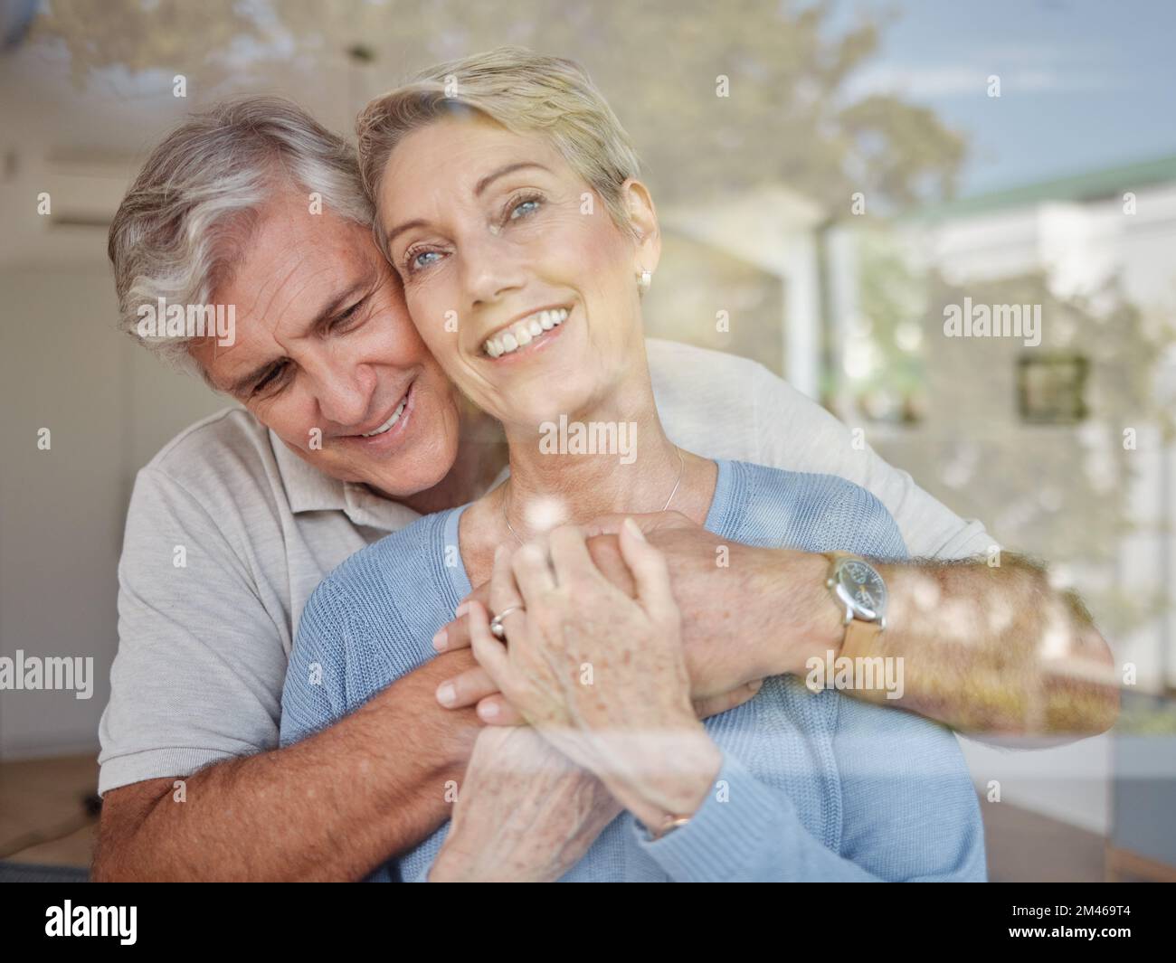 Love, window and senior couple hug, happy and bonding together for ...