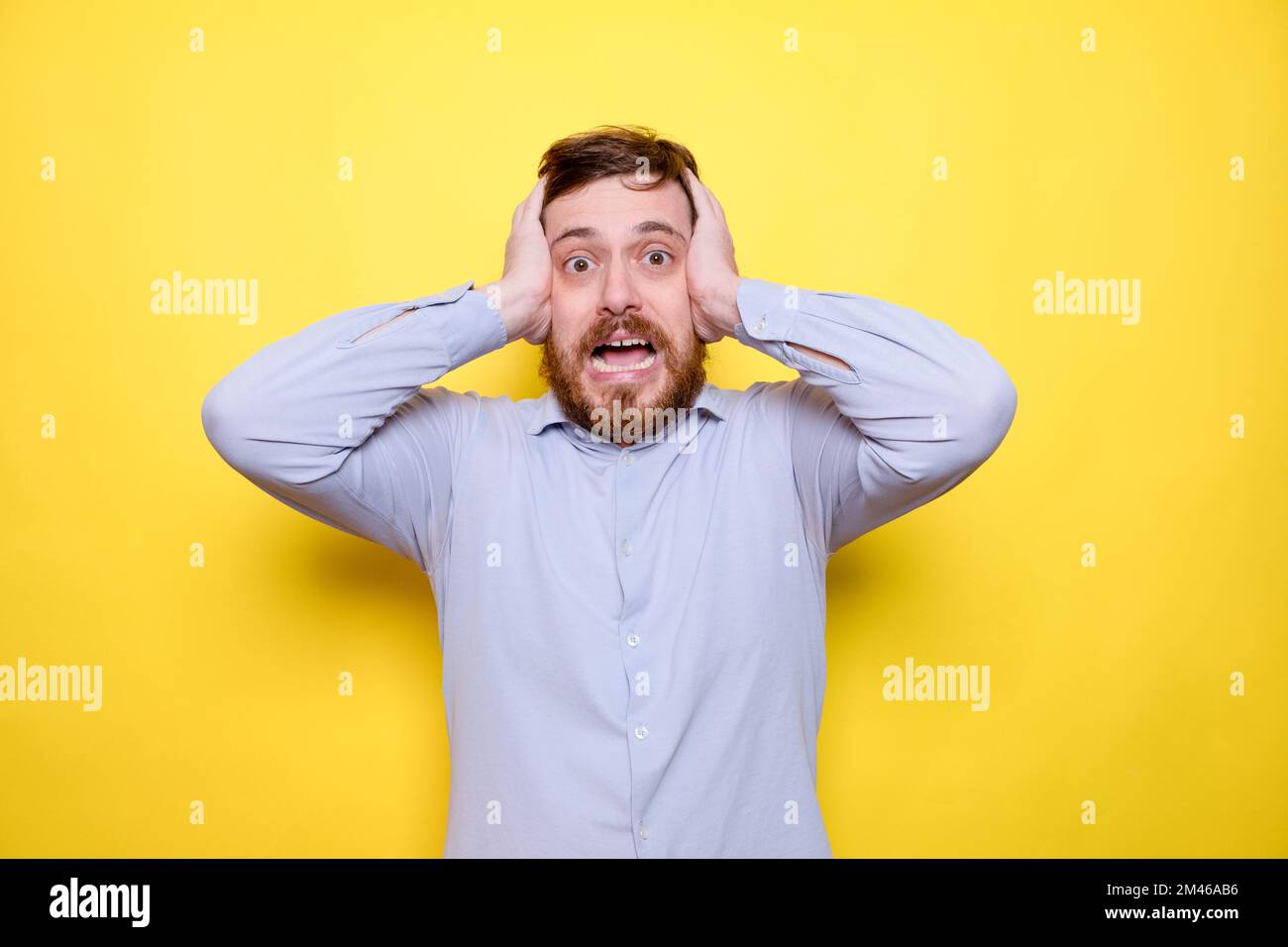 Shocked scared young man standing over yellow background Stock Photo ...