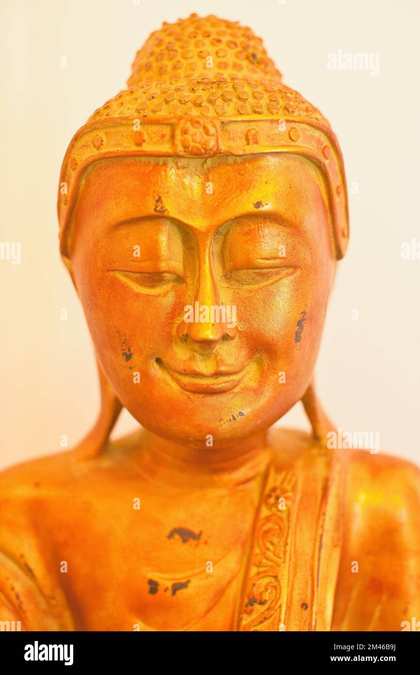 A vertical closeup of a hand-carved sculpture of Buddha, Buddhist god ...