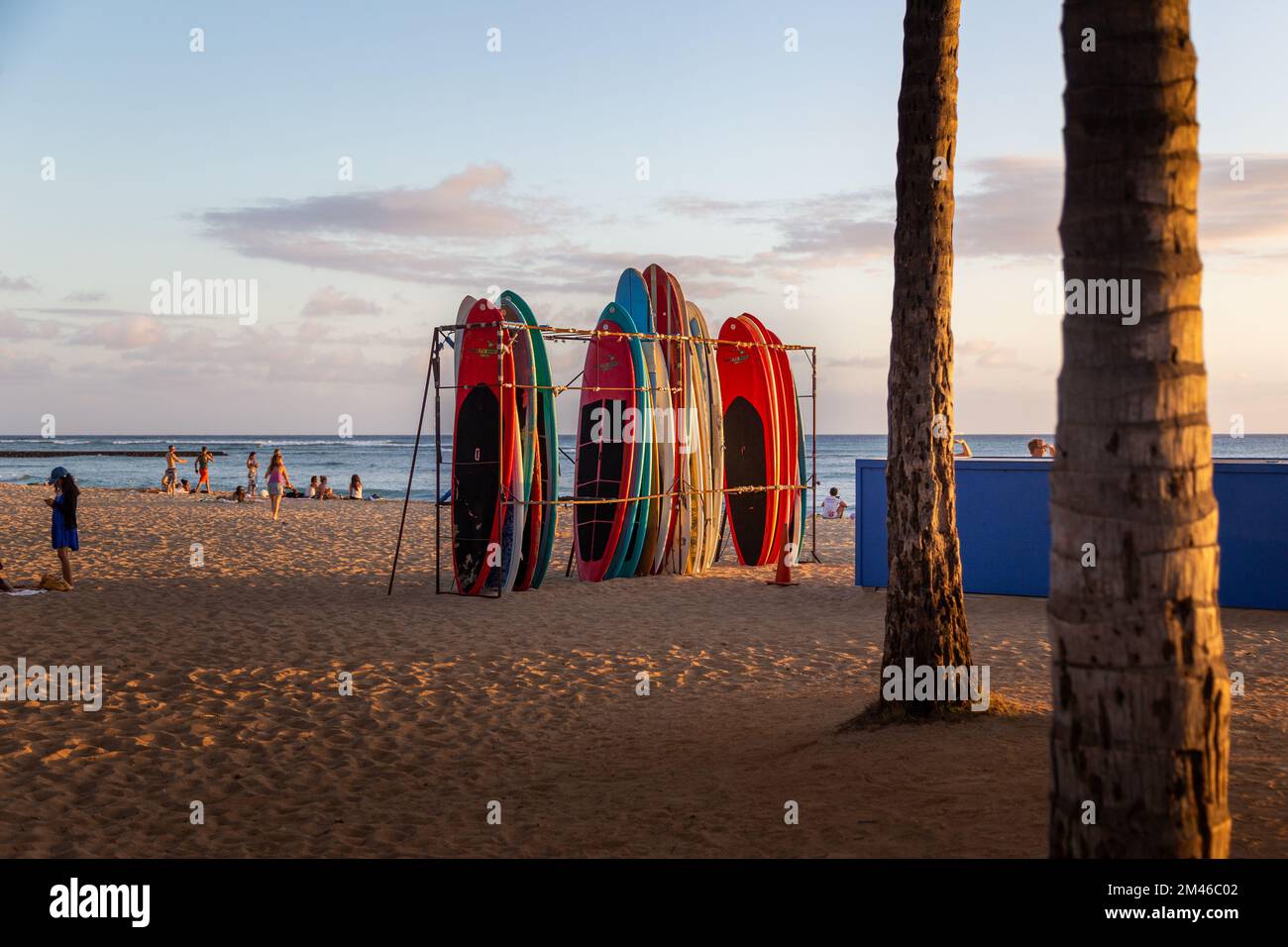Surf boards stacked into racks on Waikiki Beach in the evening light ...