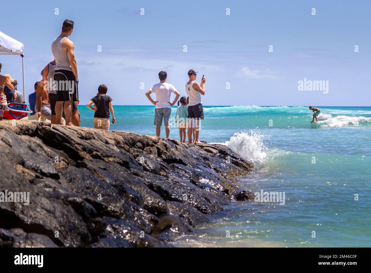 People watching the surf and surfers at Waikiki Beach, a popular ...