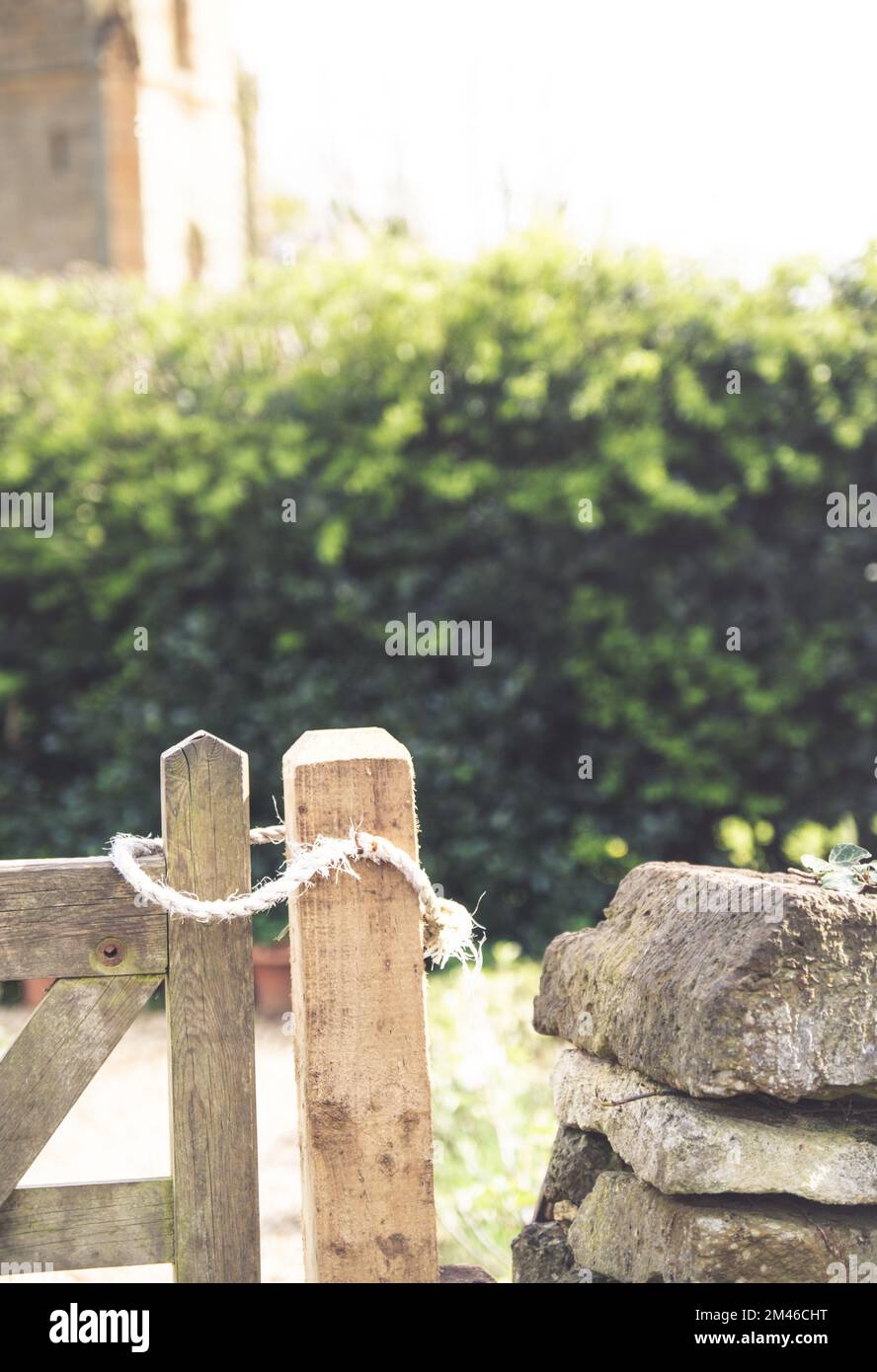 A roped garden gate over a gate post in an English country manor house ...
