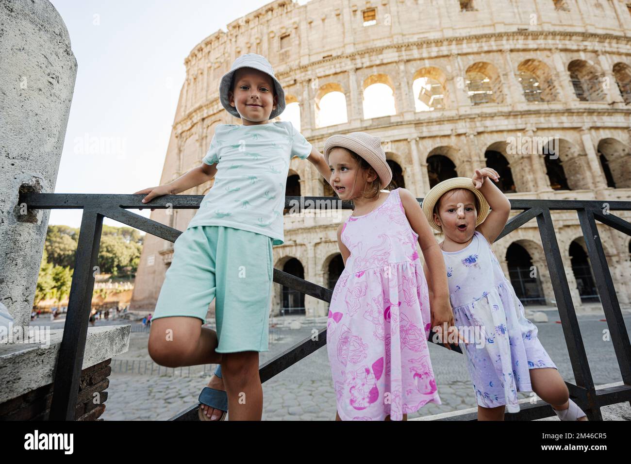 Three funny kids against Colosseum in the old city center of Rome ...