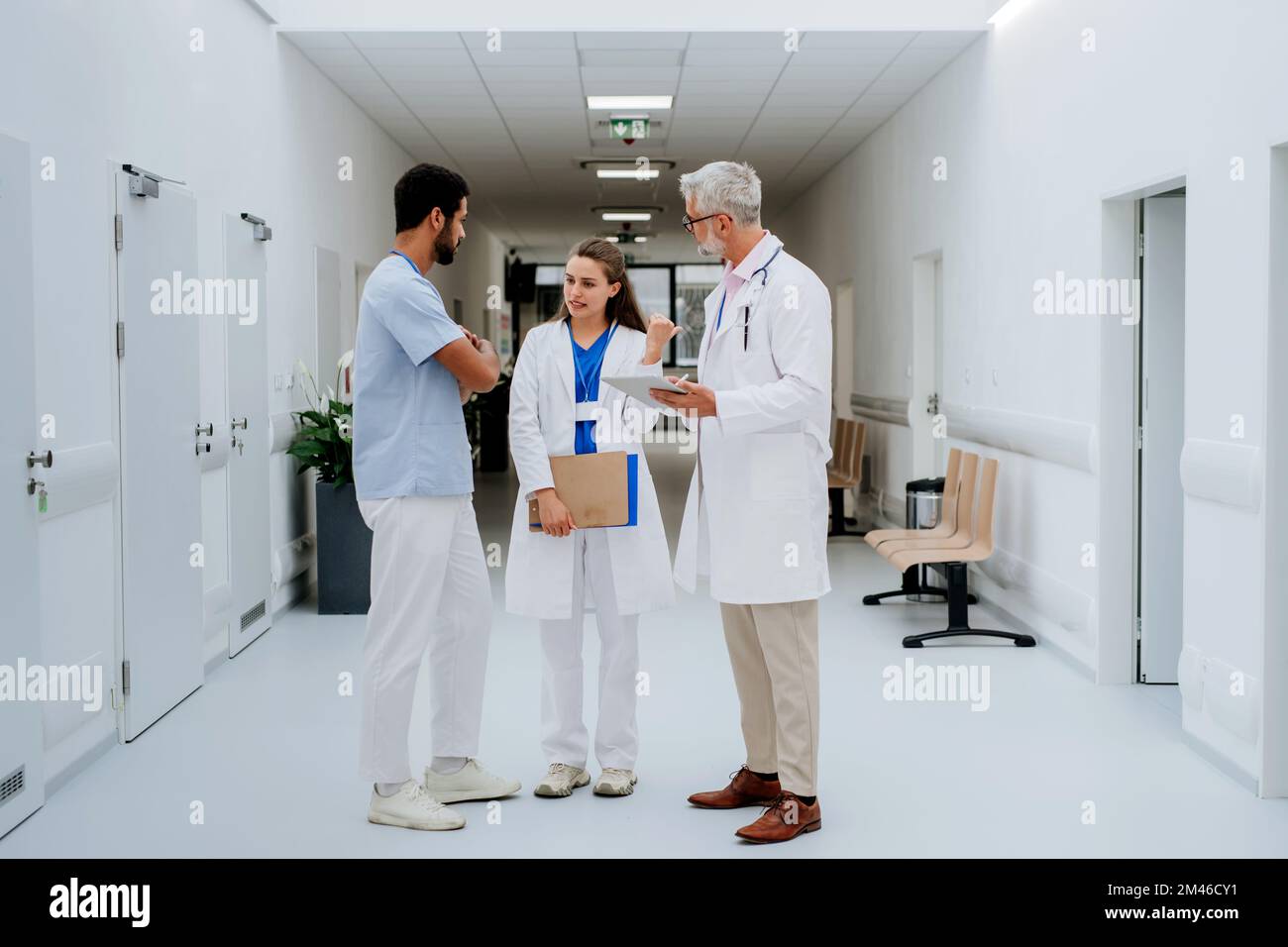 Team of doctors discussing something at hospital corridor Stock Photo ...
