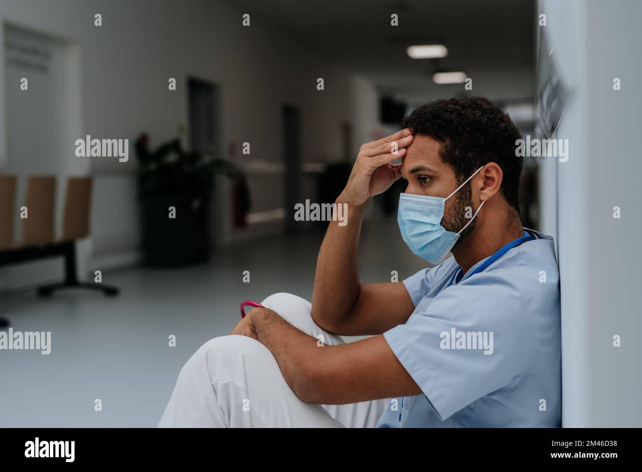 Young distressed doctor sitting at hospital corridor floor Stock Photo ...