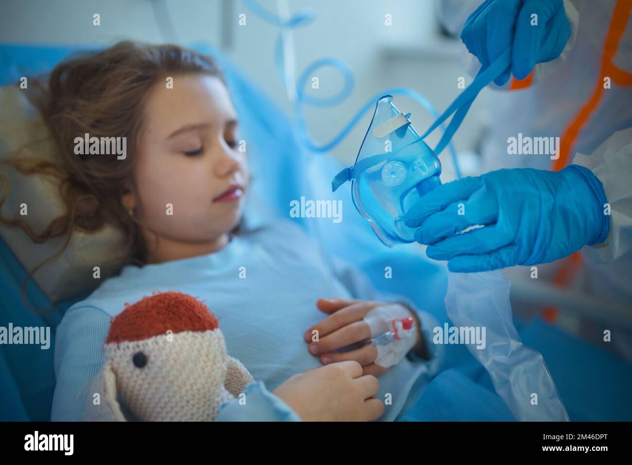 Close-up of little girl with infection disease lying in hospital room ...