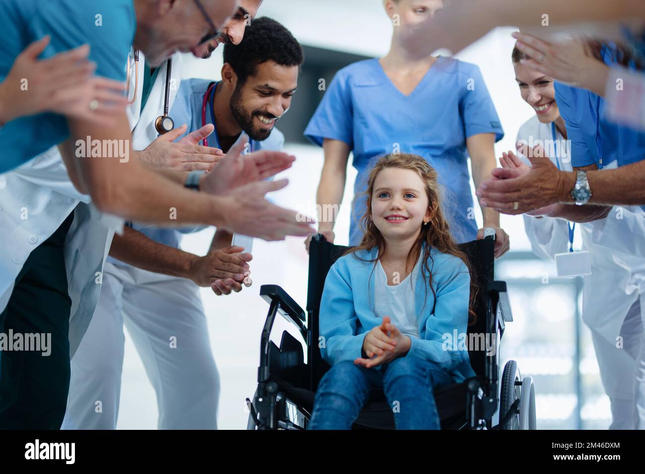 Medical staff clapping to little girl patient who recovered from ...
