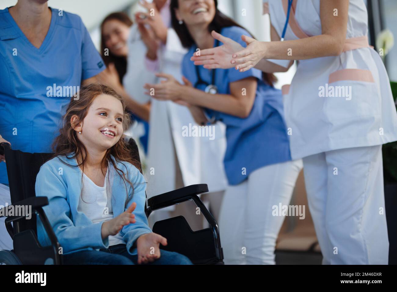 Medical staff clapping to little girl patient who recovered from ...