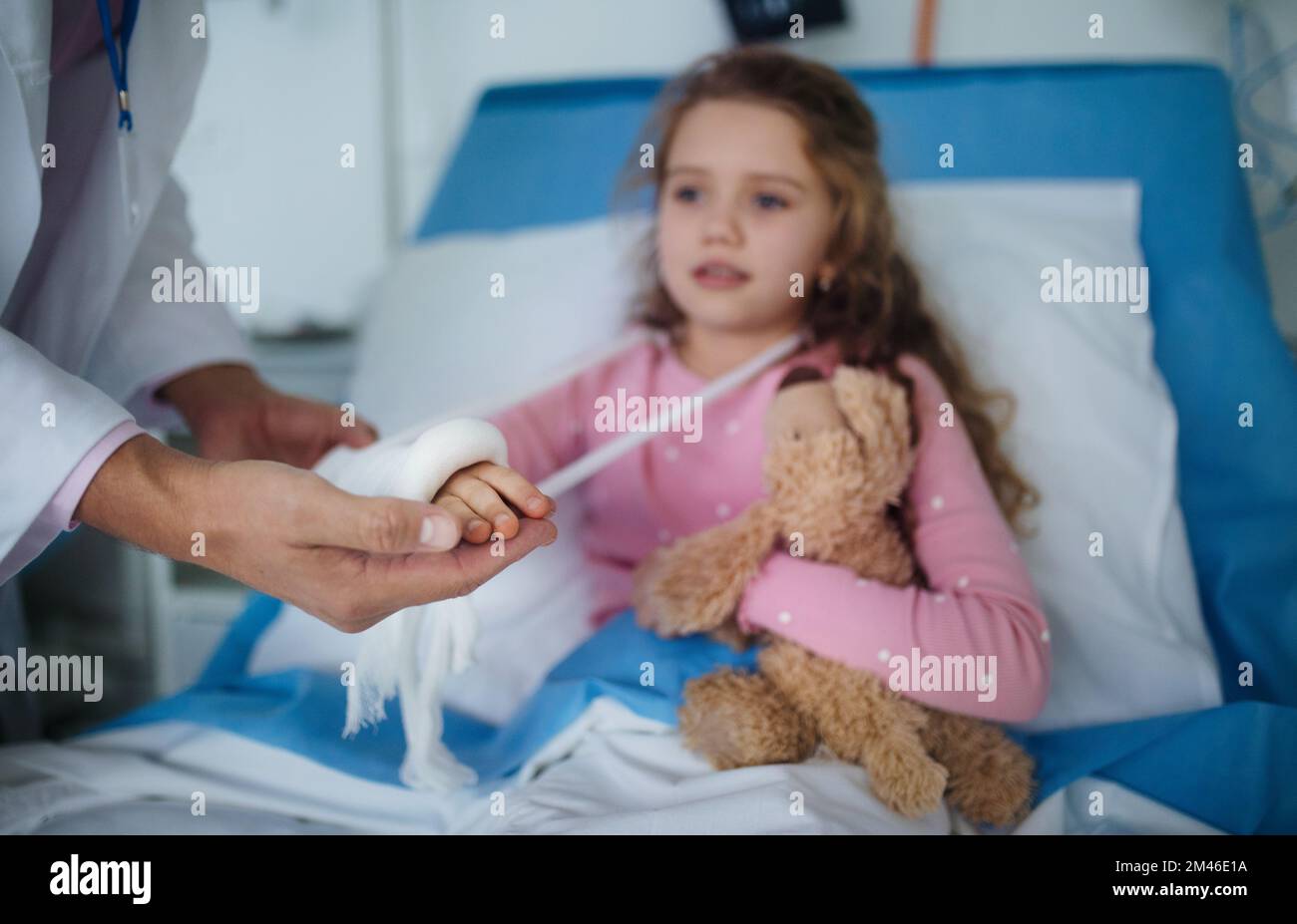 Doctor examining little girl with broken arm Stock Photo - Alamy