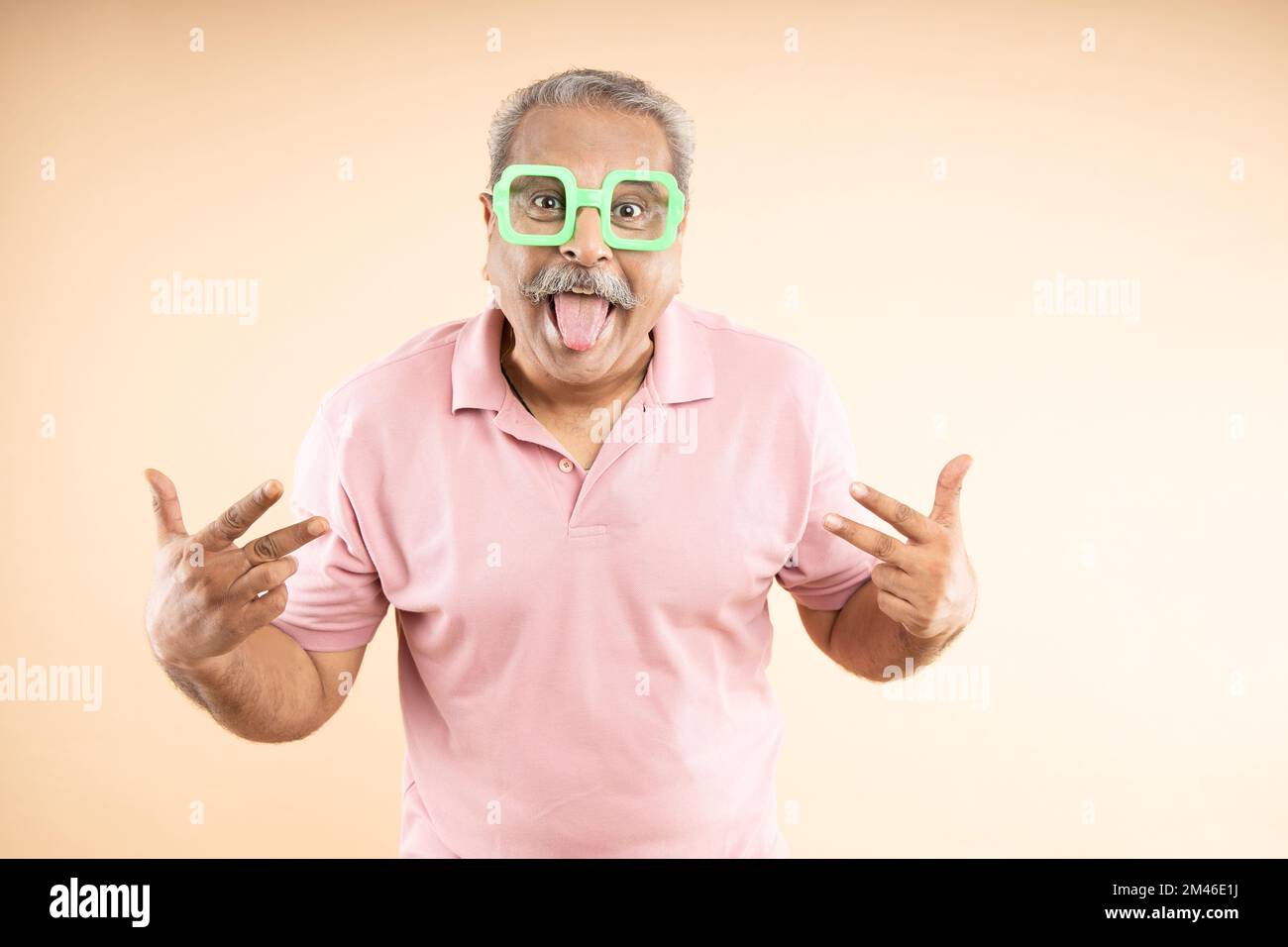 Cheerful crazy senior old man wearing funky eyeglasses shouting over ...