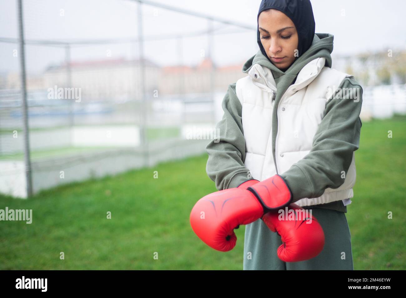 Unhappy muslim woman with boxing gloves standing outdoor Stock Photo ...
