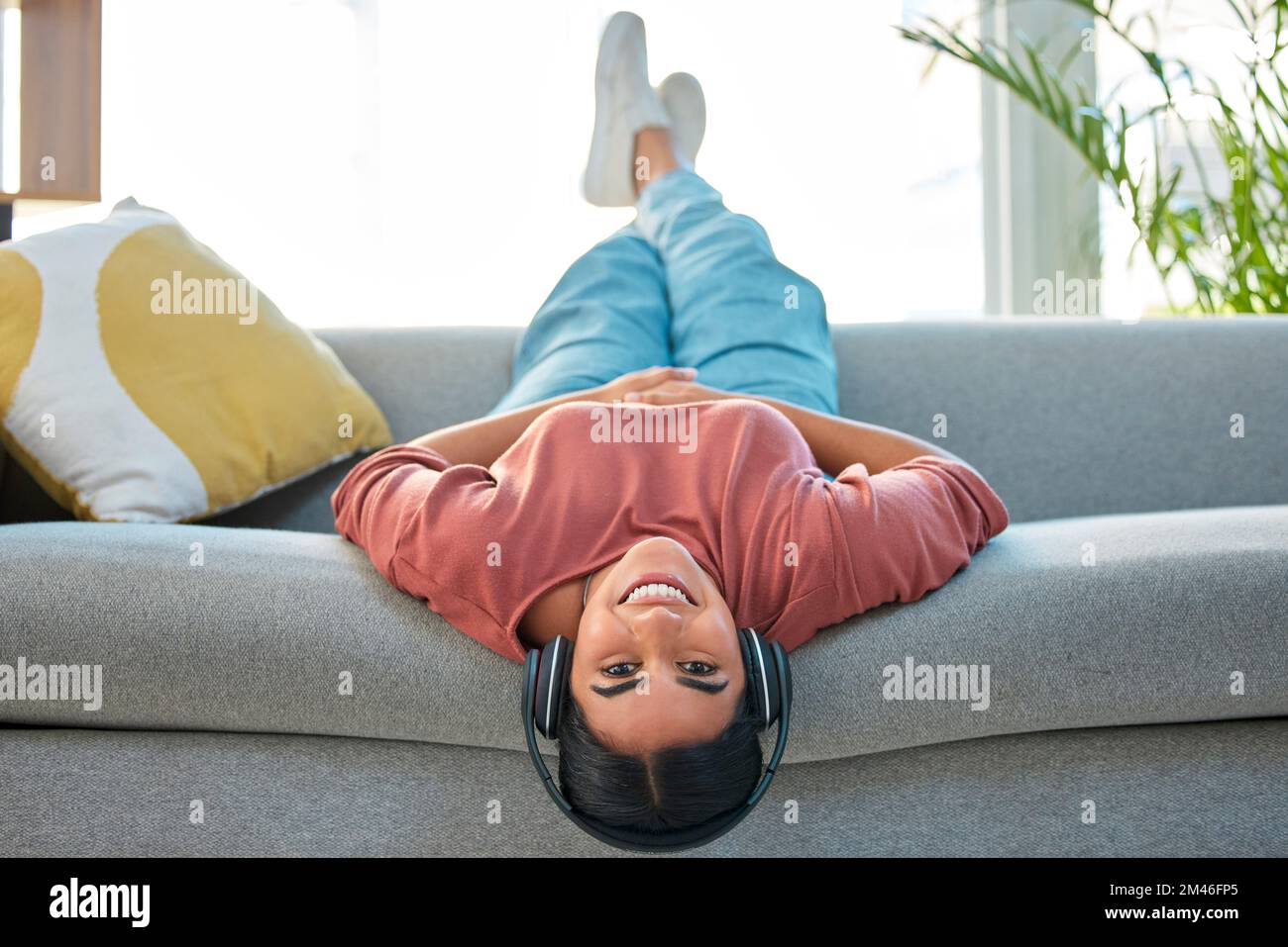 Woman, sofa and relax with headphones, music and smile in portrait ...