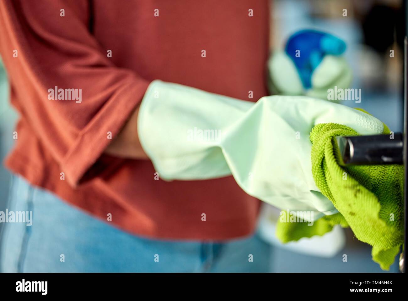 Hand, woman and sanitizing with spring cleaning a door handle surface ...