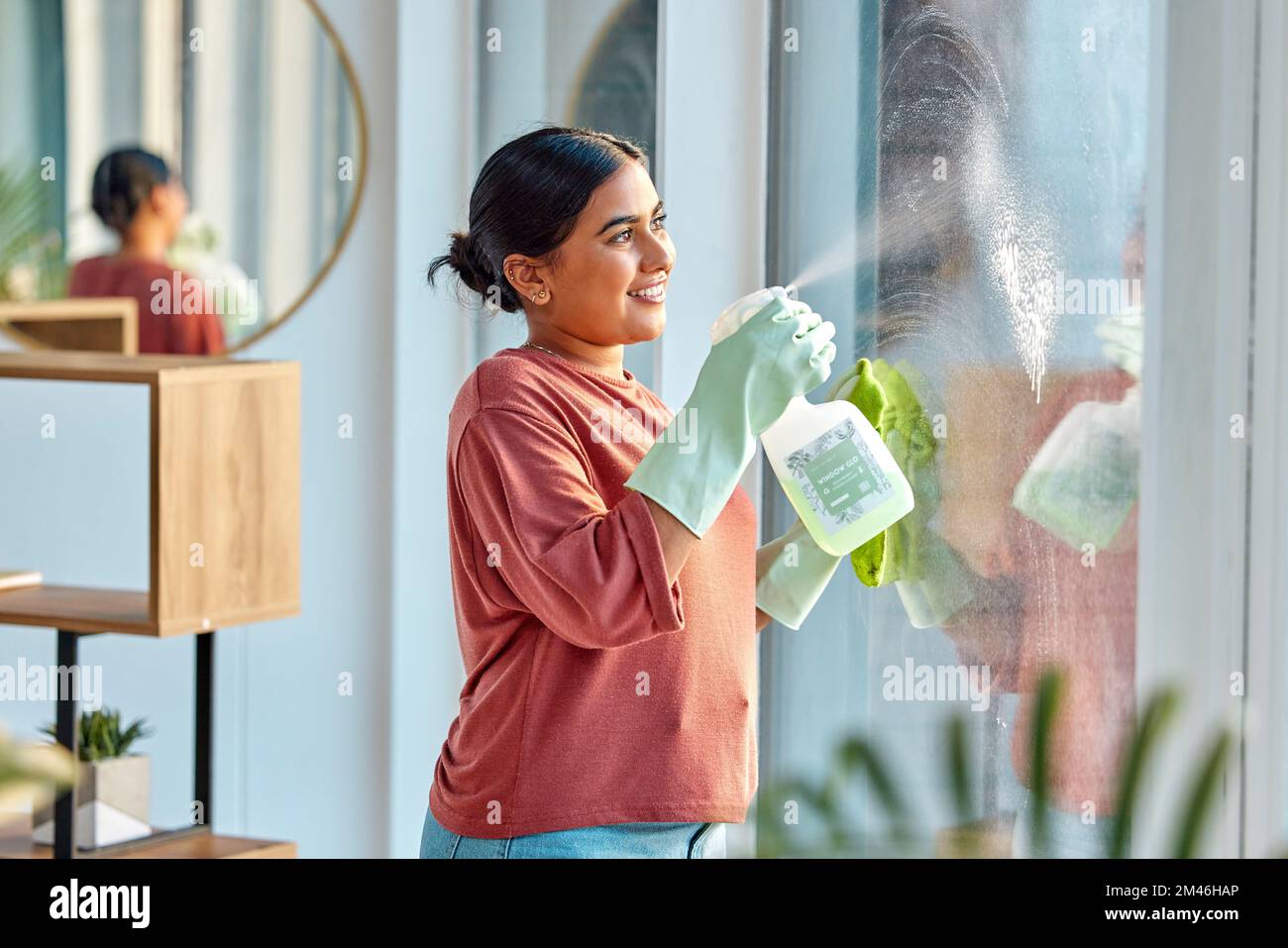 Woman, cleaning and spray product of a cleaner washing a window with a ...