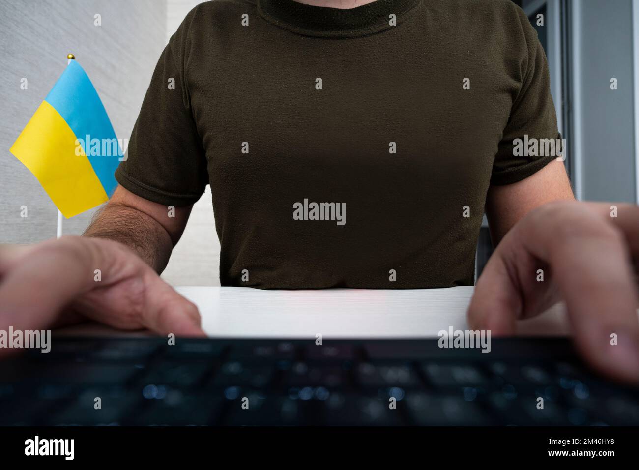 a male soldier in a military uniform is sitting at a computer. center ...
