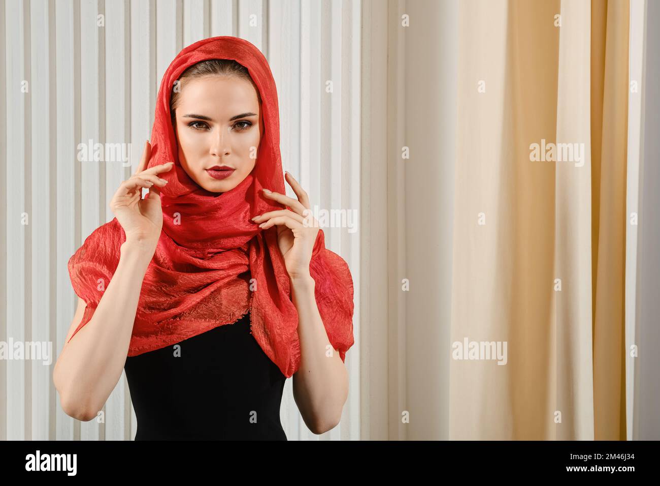 Classy woman in red silk headscarf wrapped around her head and piercing ...