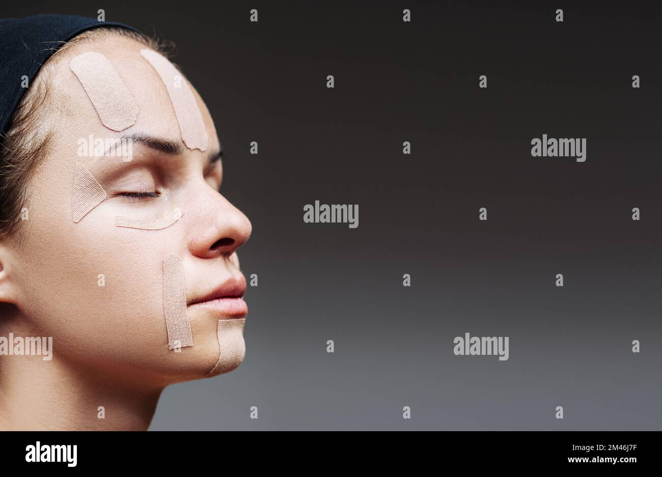 Facial kinesiology tape on female face close up Stock Photo - Alamy