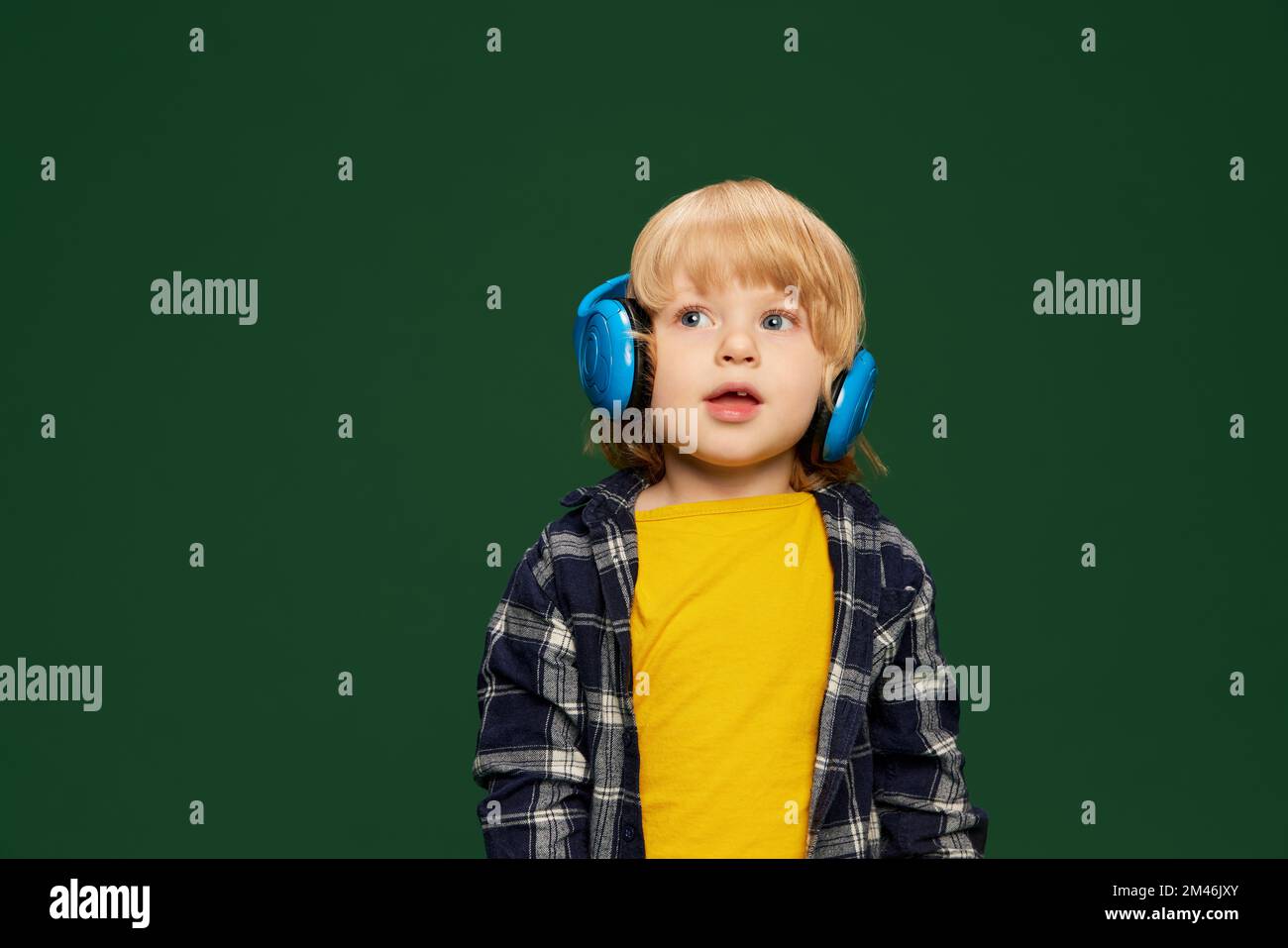 Portrait of little boy, child posing in headphones, listening to fairy ...
