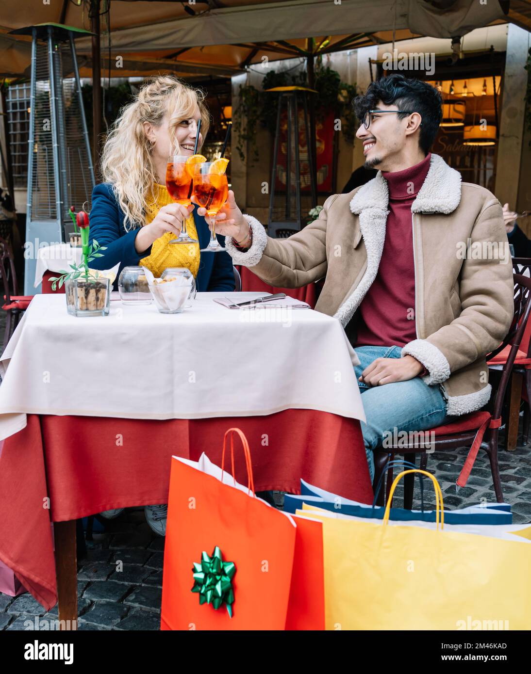 Multiethnic couple sitting toast after shopping in downtown Stock Photo ...