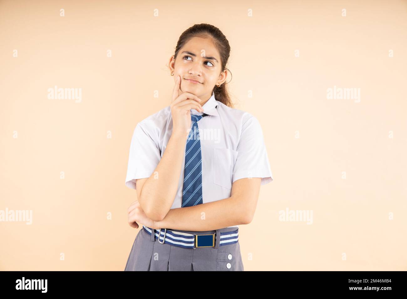 Modern Indian student schoolgirl wearing school uniform thinking ...
