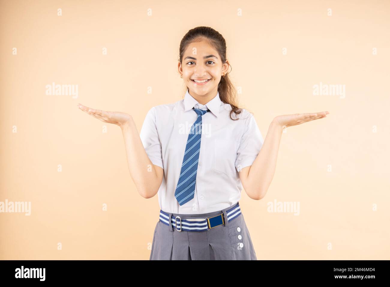 Happy Indian student schoolgirl wearing school uniform standing with ...