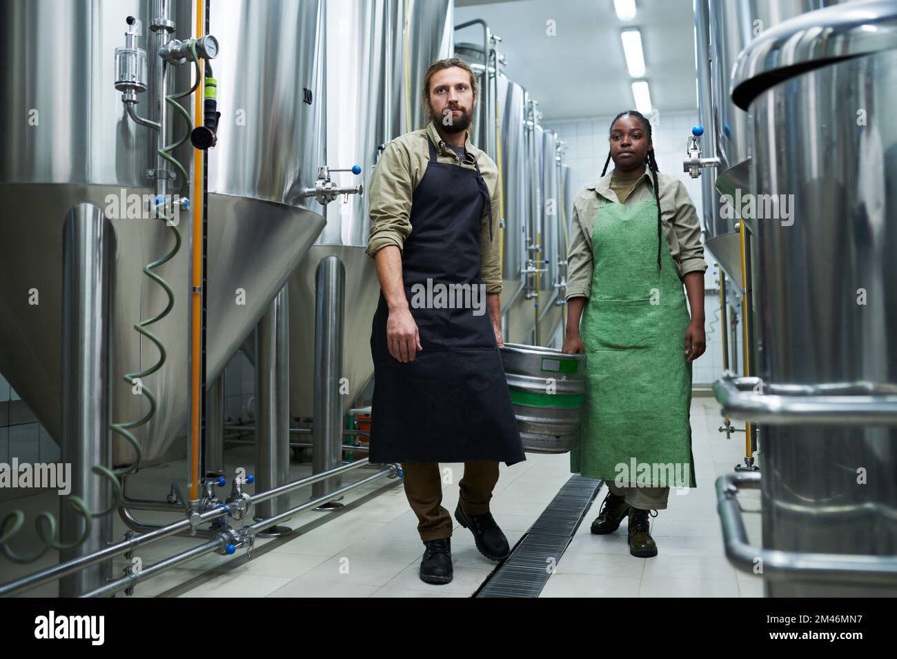 Brewery workers carrying keg with fresh beer to warehouse Stock Photo ...
