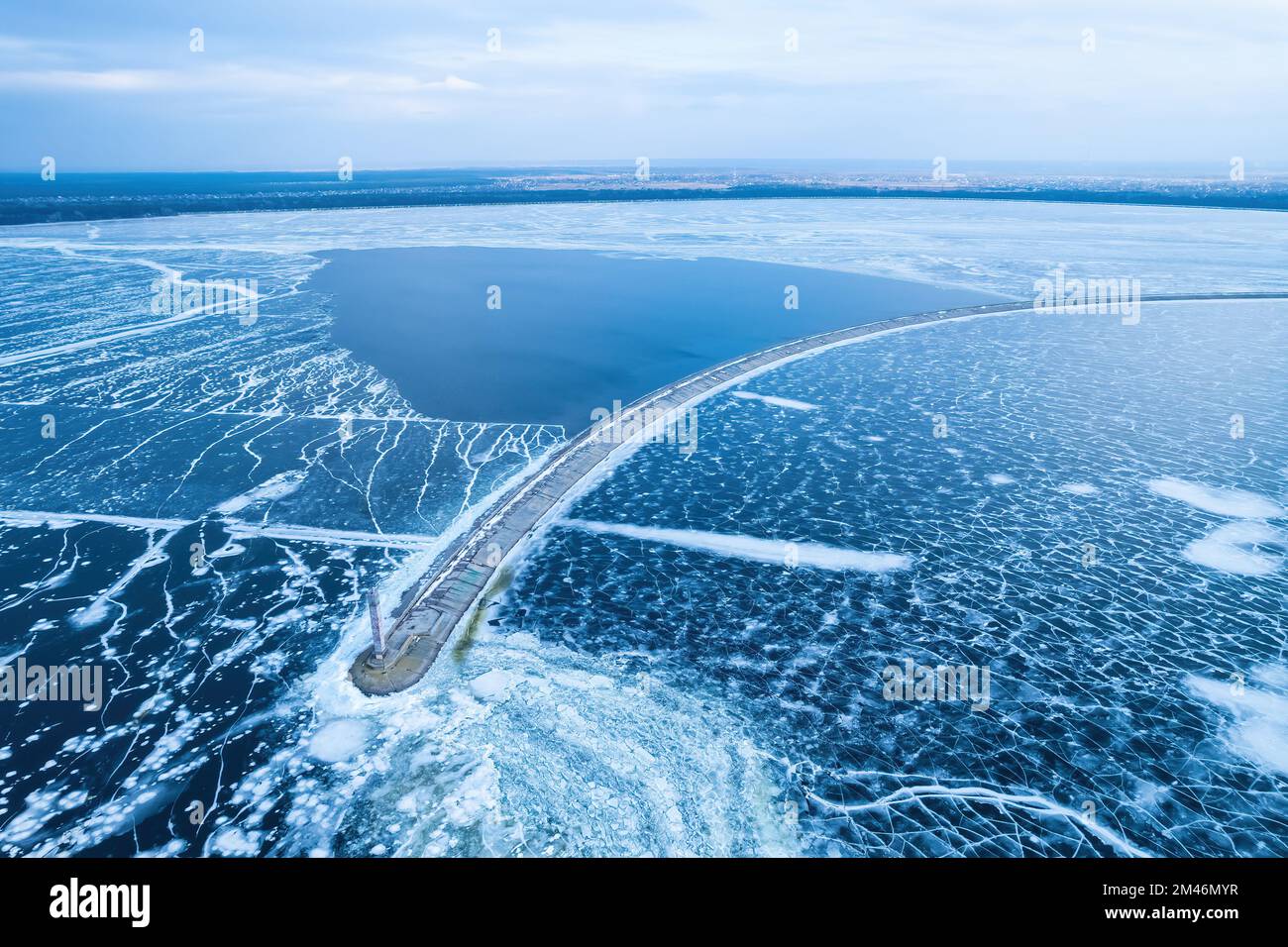 aerial view of a lonely lighthouse in the frozen sea. Frozen blue ice ...