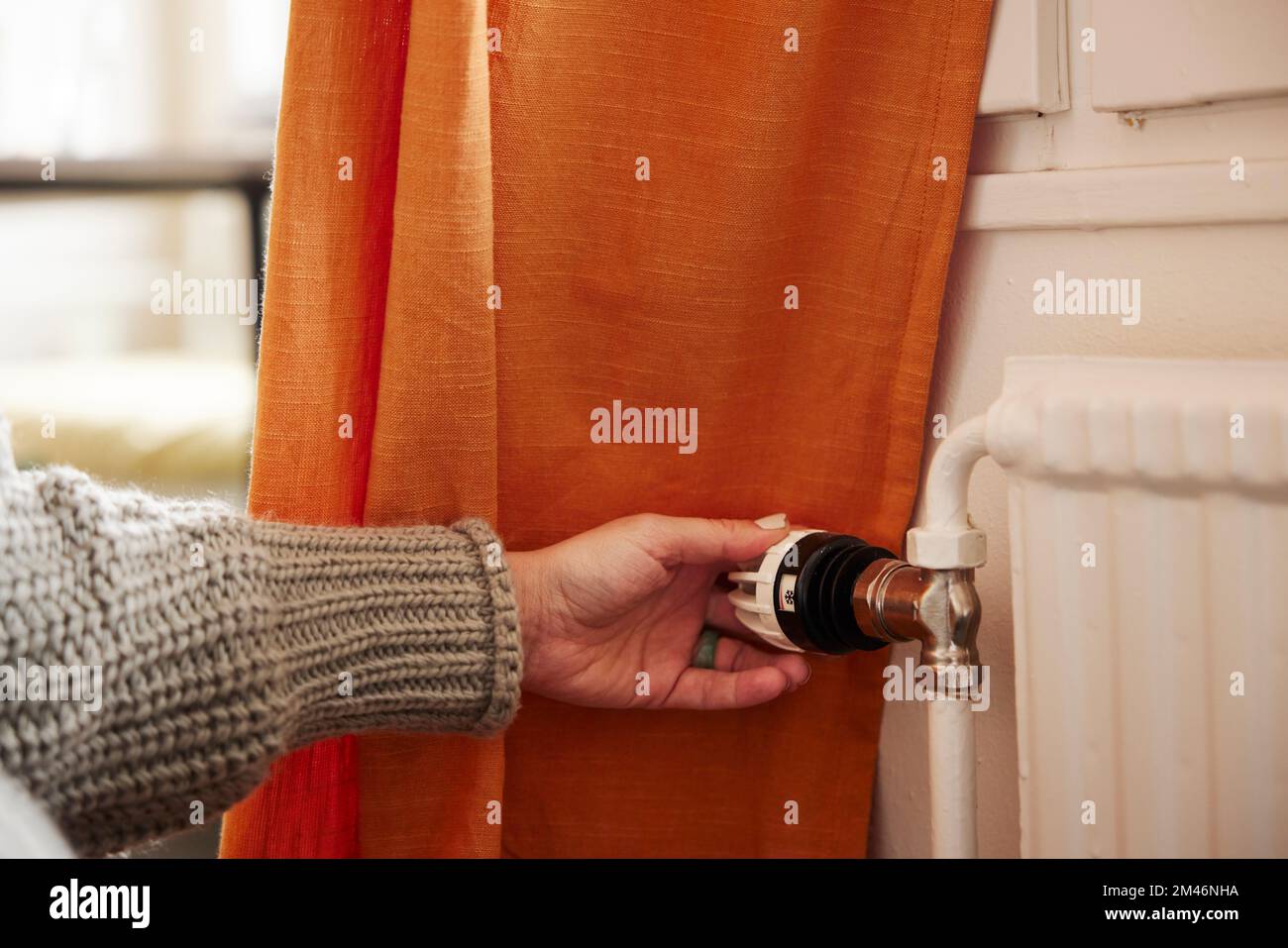 Woman turning radiator thermostat Stock Photo - Alamy