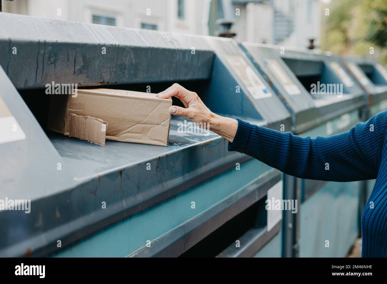 Woman's hand putting cardboard box into recycling bin Stock Photo - Alamy