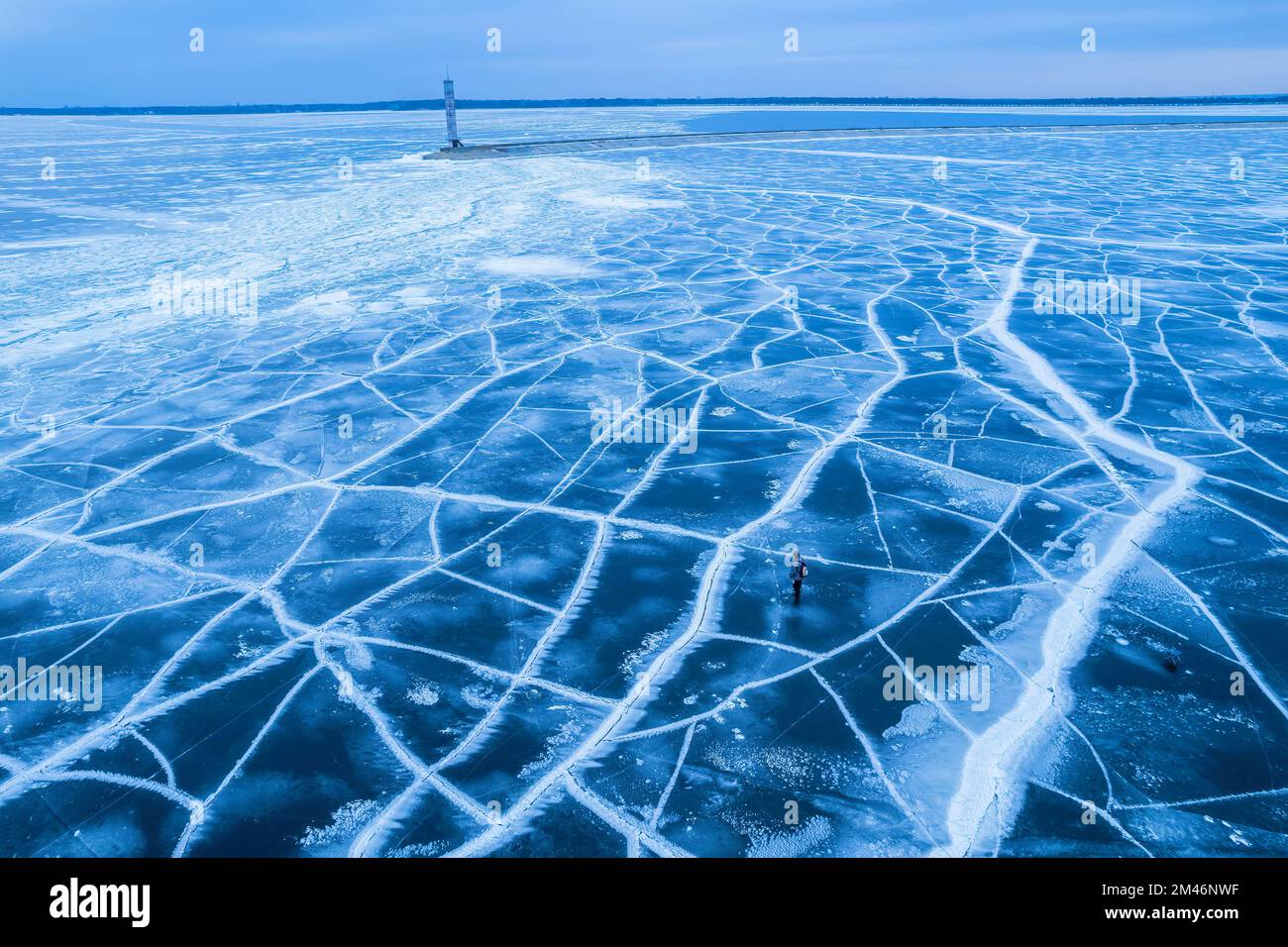 aerial view of a lonely lighthouse in the frozen sea. Frozen blue ice ...