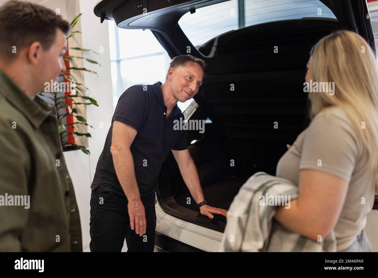 Customers in car dealership office Stock Photo - Alamy