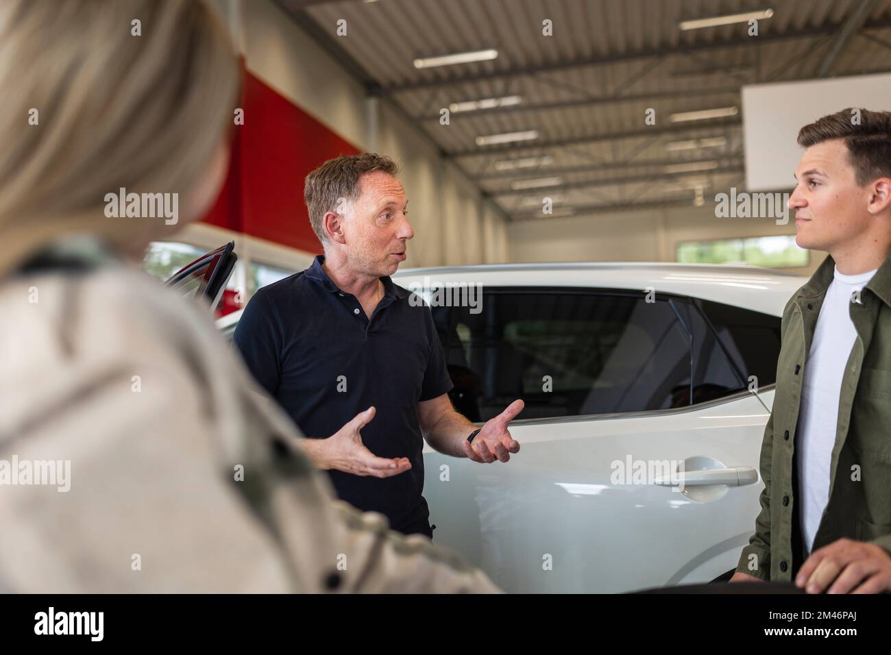 Customers in car dealership office Stock Photo - Alamy