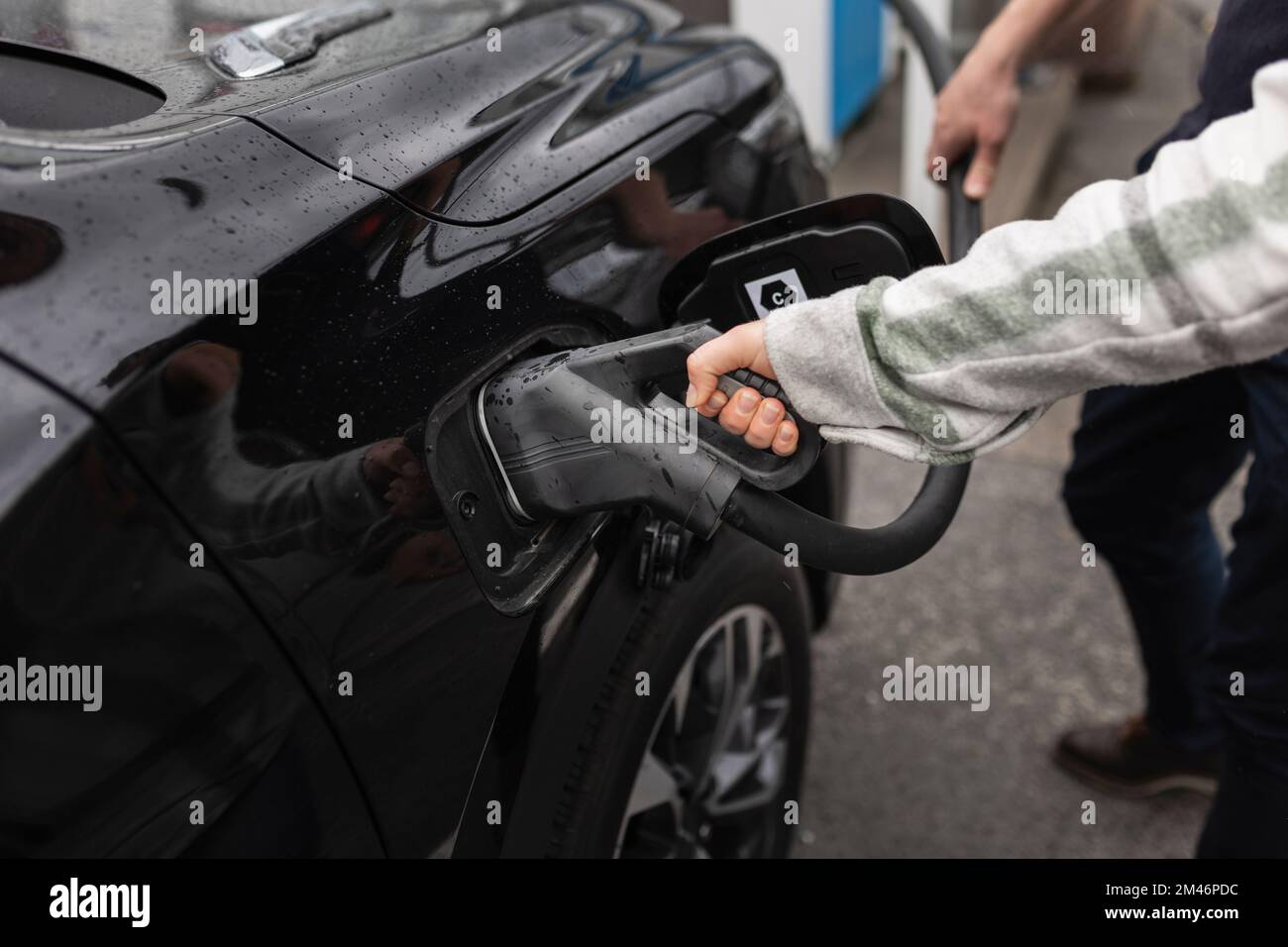 Hand charging electric car Stock Photo - Alamy