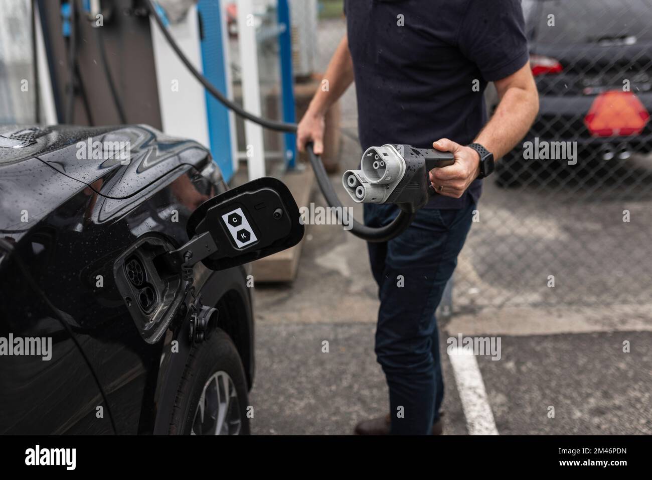 Man charging electric car Stock Photo - Alamy