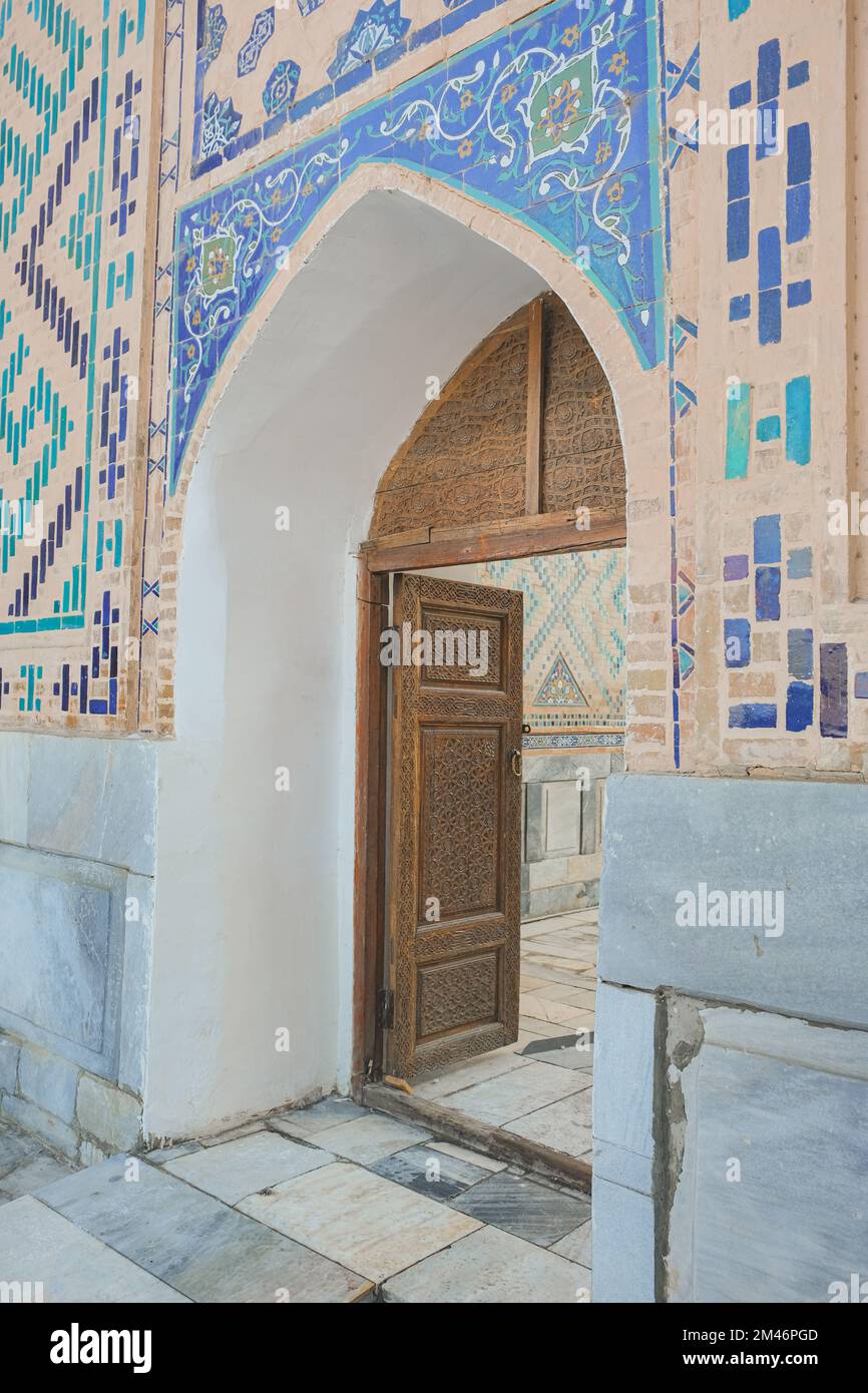 Carved wooden door in an old madrasah on Registan Square. Samarkand ...