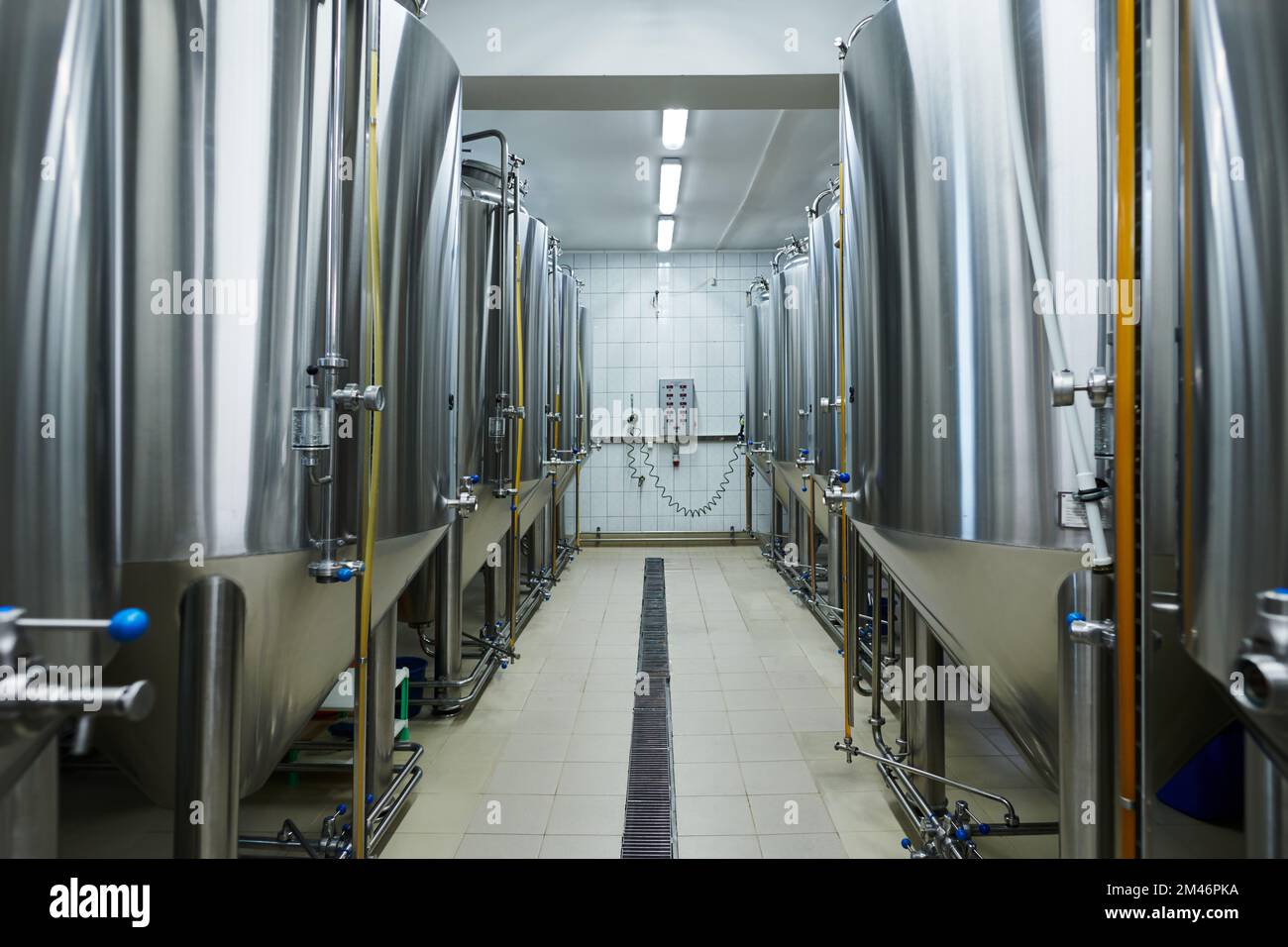 Microbrewery interior with many still tanks full of fermintating beer ...