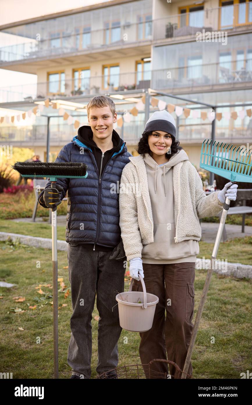 Young people holding garden tools Stock Photo - Alamy