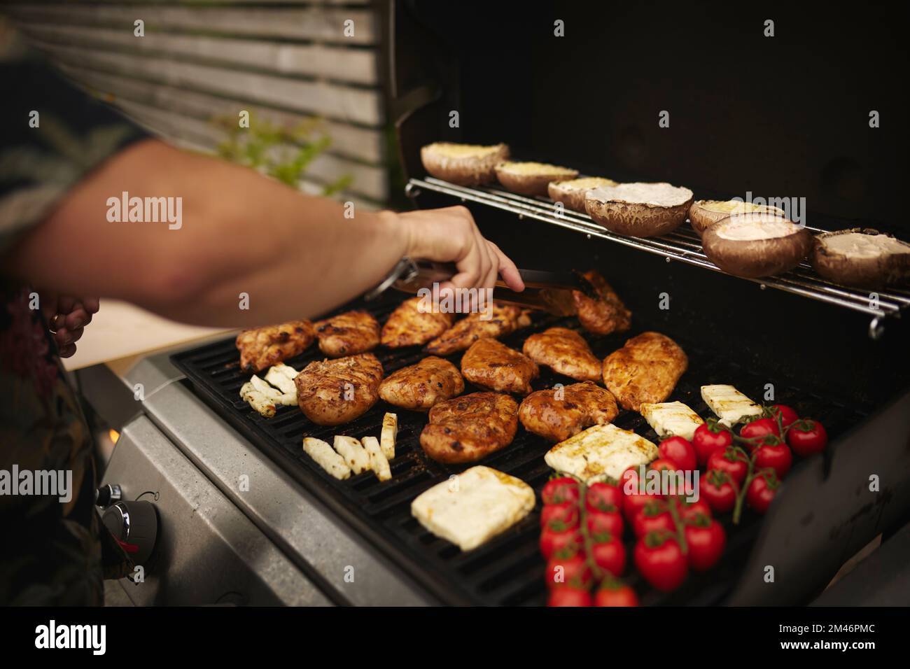 Man grilling meat on barbecue Stock Photo - Alamy
