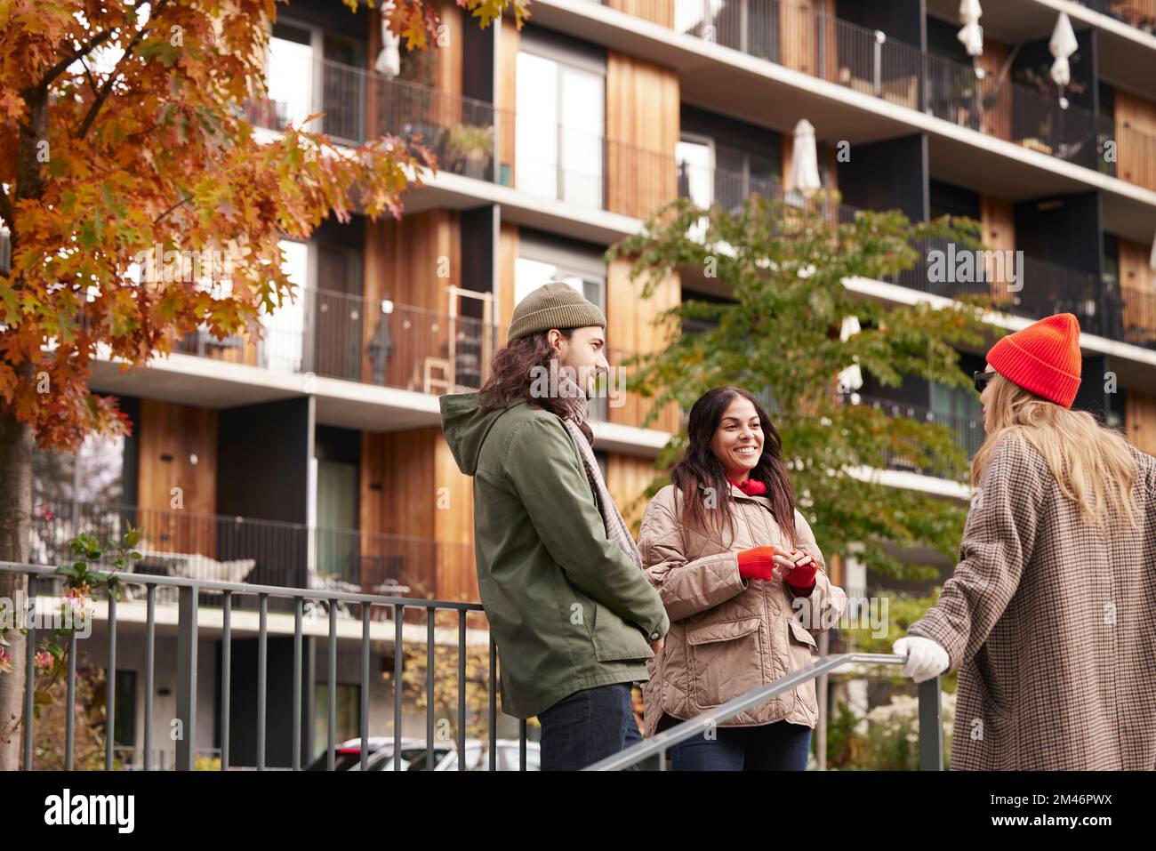 Smiling friends talking together Stock Photo - Alamy