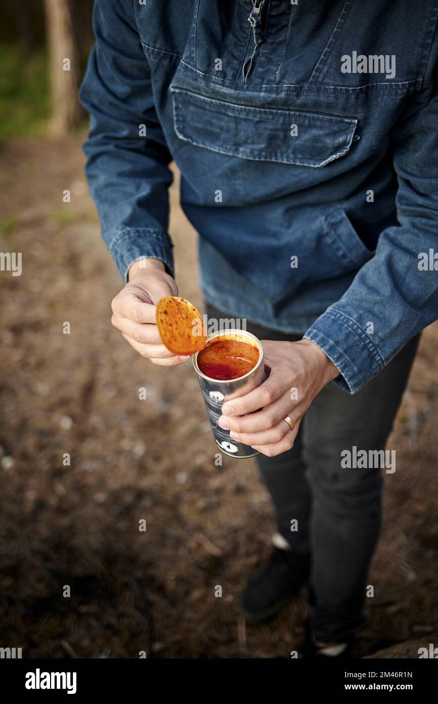 Mid section of person opening can Stock Photo - Alamy