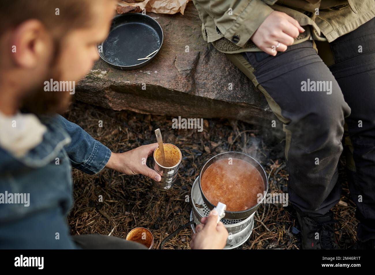 Heating food on camping stove Stock Photo - Alamy