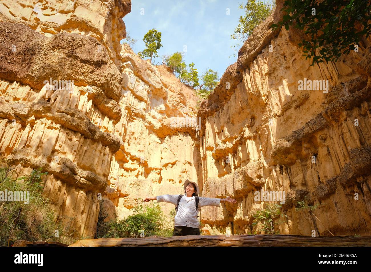 Female geologist with backpack exploring nature trail in forest and ...
