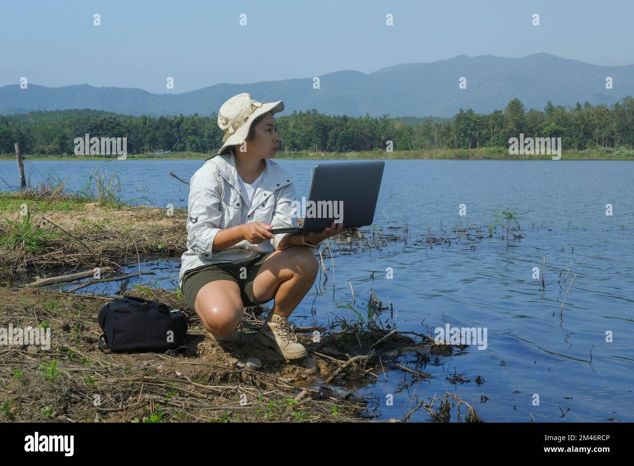 Female environmentalist using laptop computer to record pathogen ...
