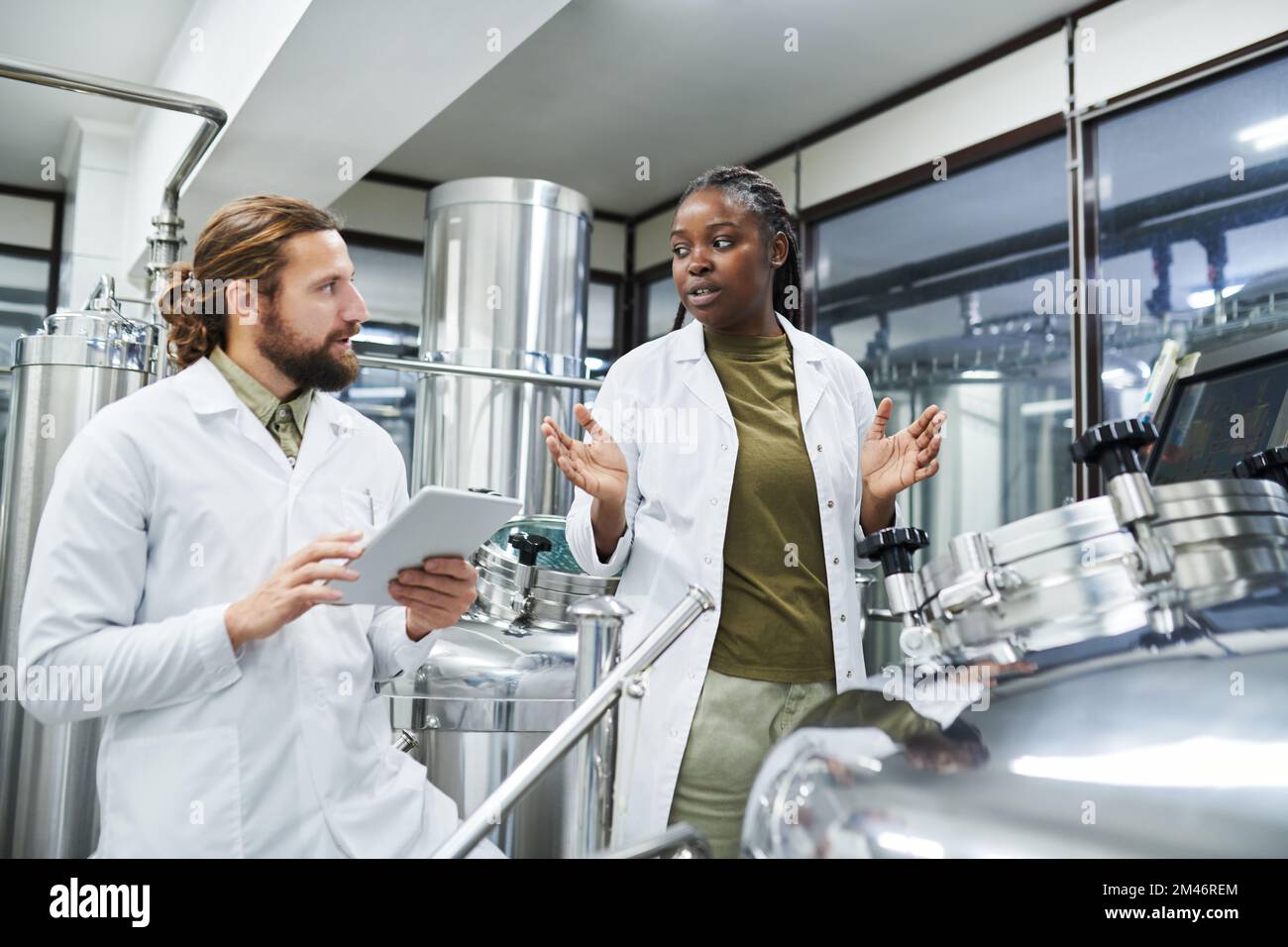 Diverse team of technologists checking equipment at brewery Stock Photo ...