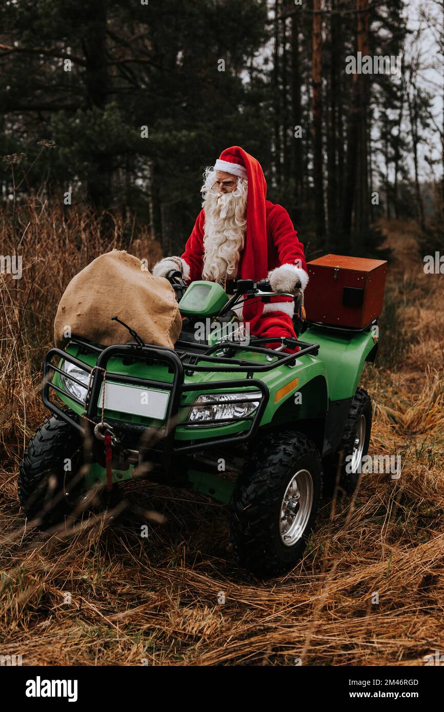 Man wearing Santa costume riding lawn mower Stock Photo - Alamy