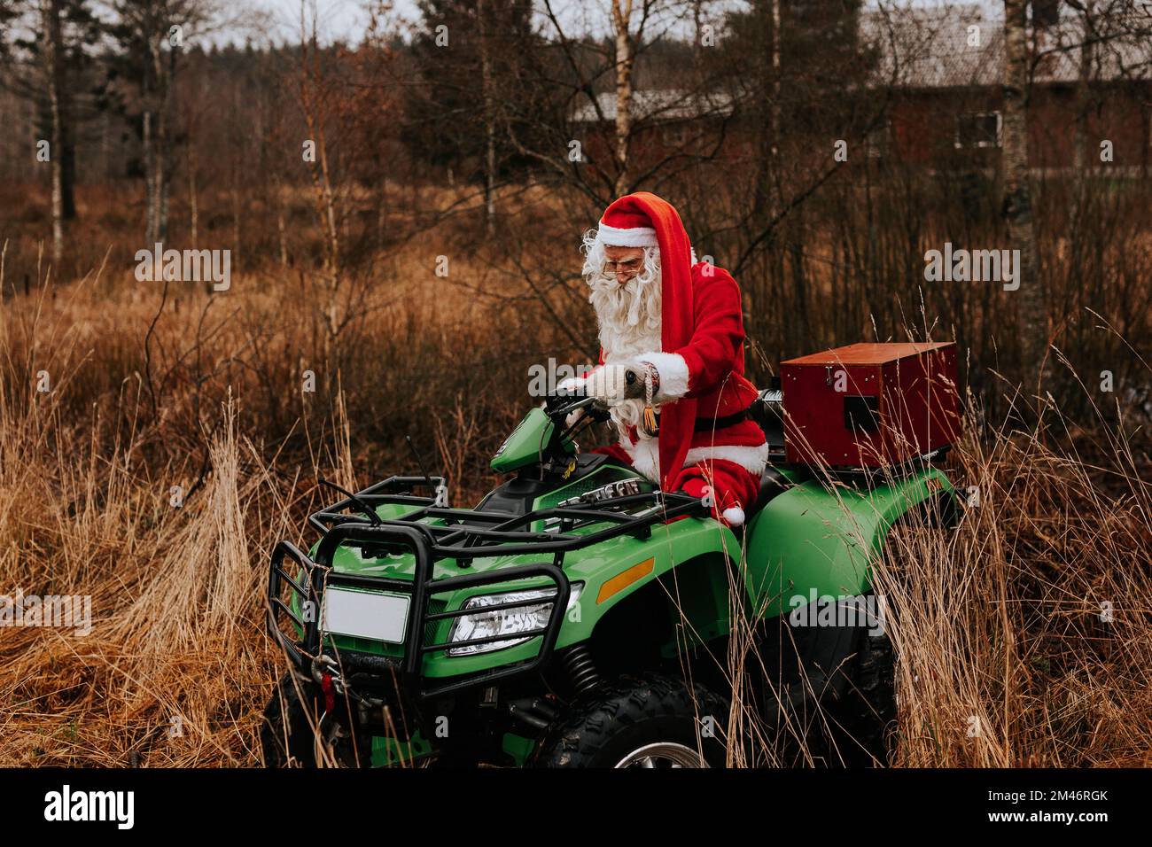 Man wearing Santa costume riding lawn mower Stock Photo - Alamy