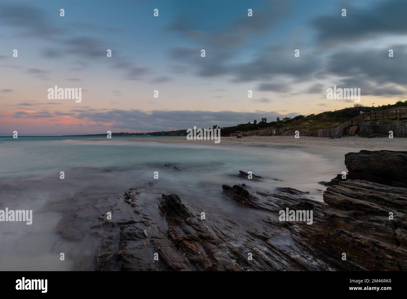 sunset over the picturesque white sand beach and turquoise waters at La ...