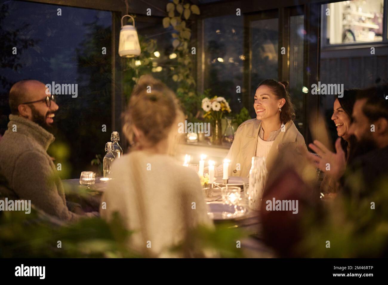 Happy friends having evening meal together Stock Photo - Alamy