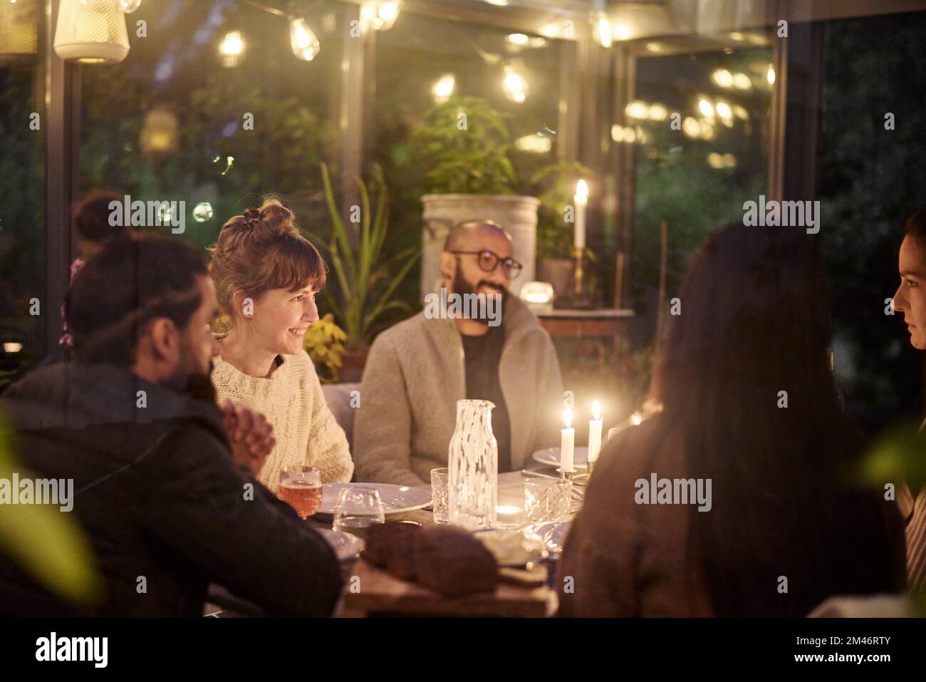 Happy friends having evening meal together Stock Photo - Alamy